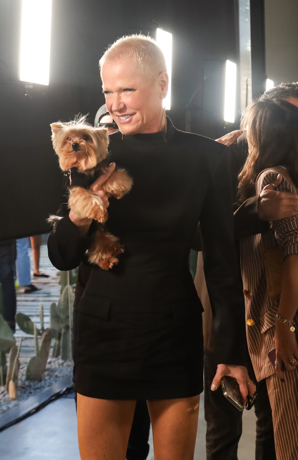 Com look all black, Xuxa leva cachorra para desfile de Sasha em São Paulo