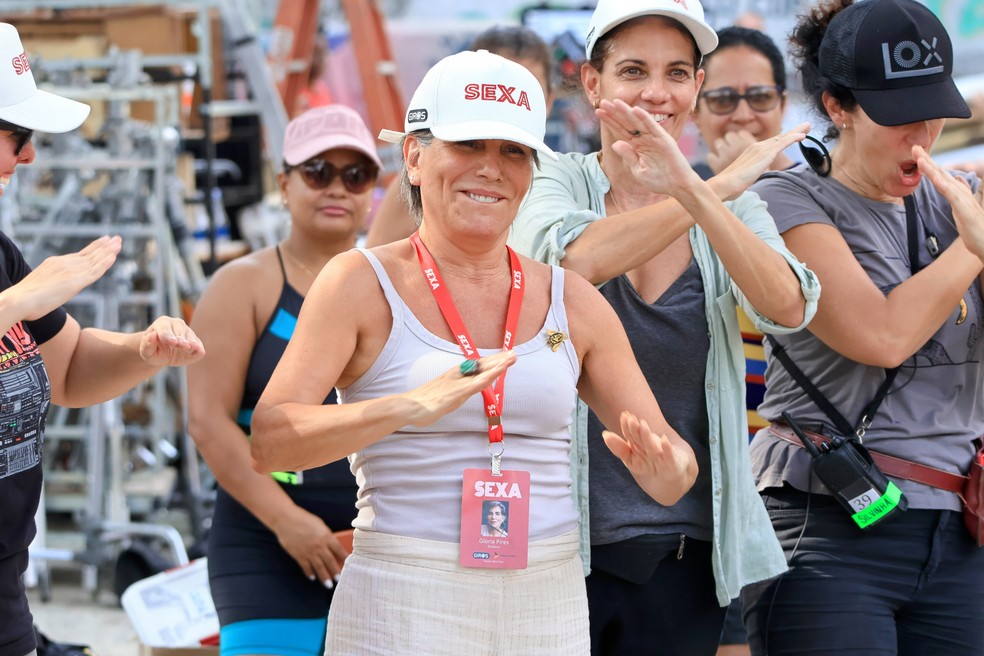 Gloria Pires recebe flores e se emociona com fãs durante gravação na praia