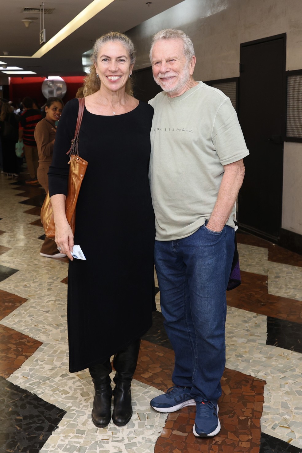 Jonas Bloch surge sorridente ao lado da esposa em estreia de peça no Rio