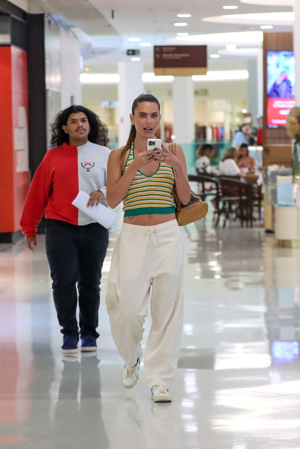 De top, Mariana Goldfarb acena e manda beijos para fotógrafos em passeio