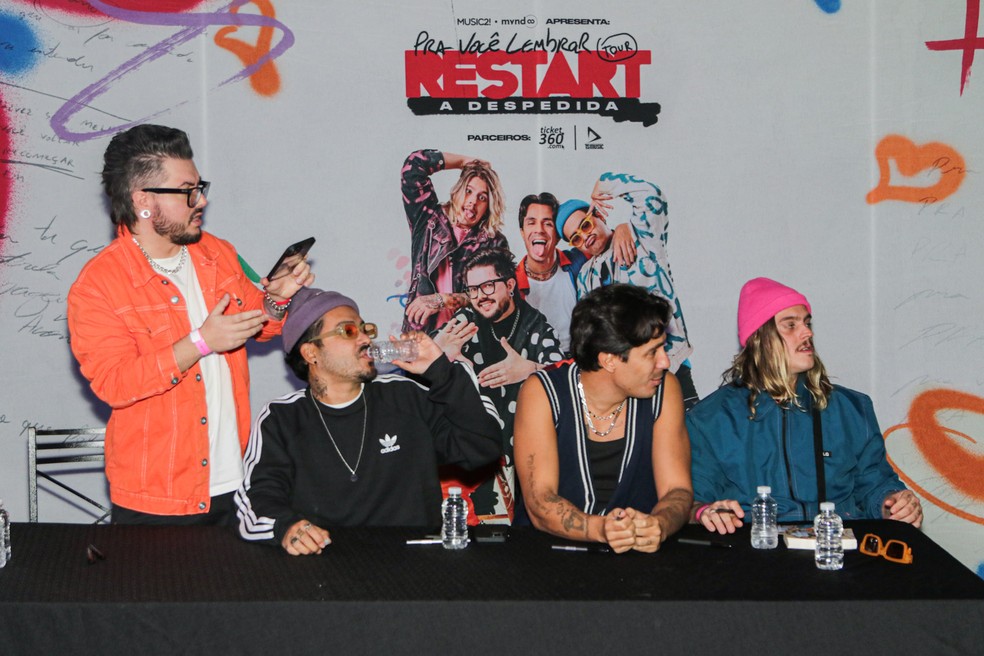 Integrantes da banda Restart atendem fãs em ação de turnê de despedida