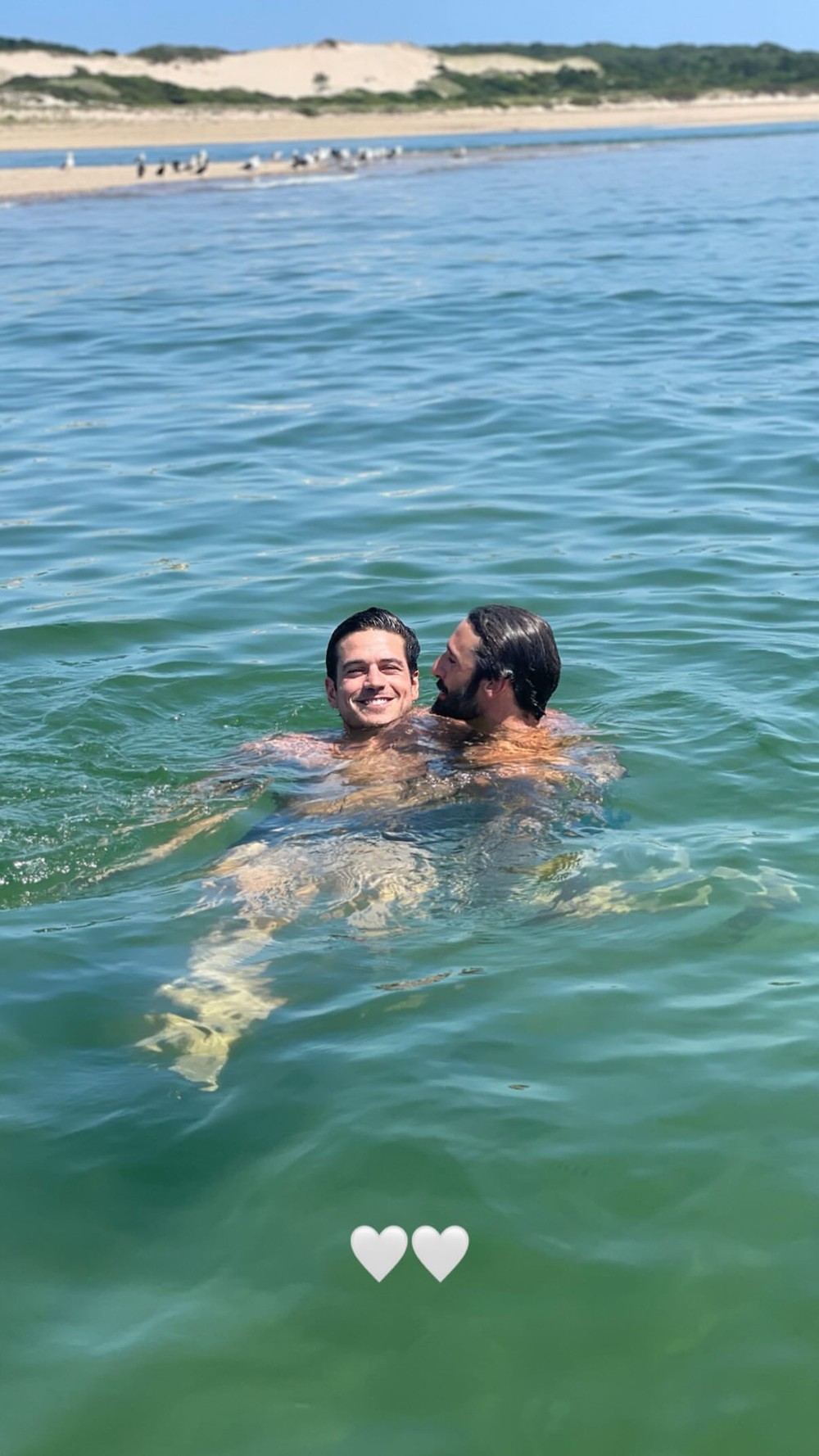 Marco Pigossi e o marido, Marco Calvani, curtem romance em banho de mar