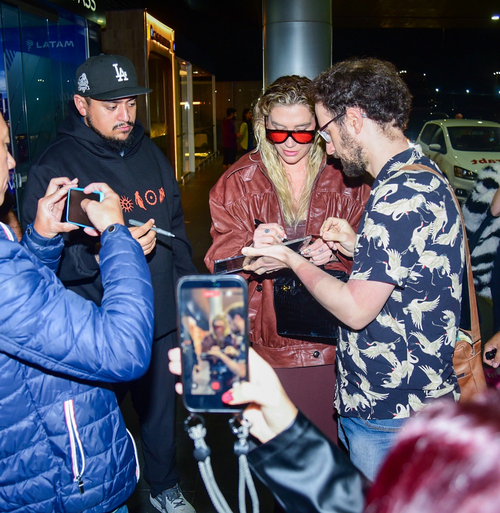 Kesha posa no aeroporto de Guarulhos e atende fãs após show; veja fotos