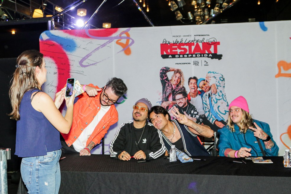 Integrantes da banda Restart atendem fãs em ação de turnê de despedida