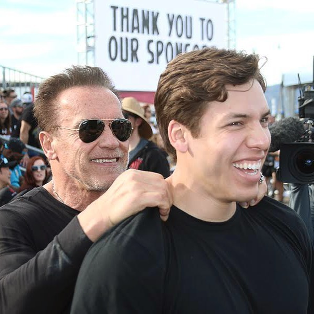 Filho que Arnold Schwarzenegger teve com a governanta fica de fora do casamento do meio-irmão