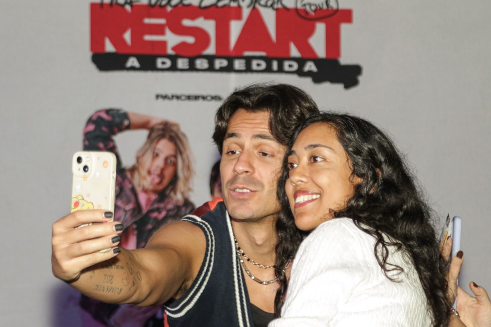 Integrantes da banda Restart atendem fãs em ação de turnê de despedida