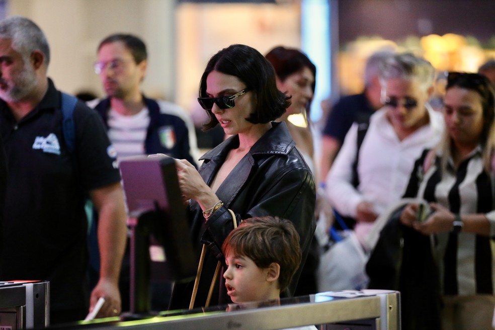 Com vestido de R$ 12 mil, Isis Valverde embarca em voo com o filho, Rael