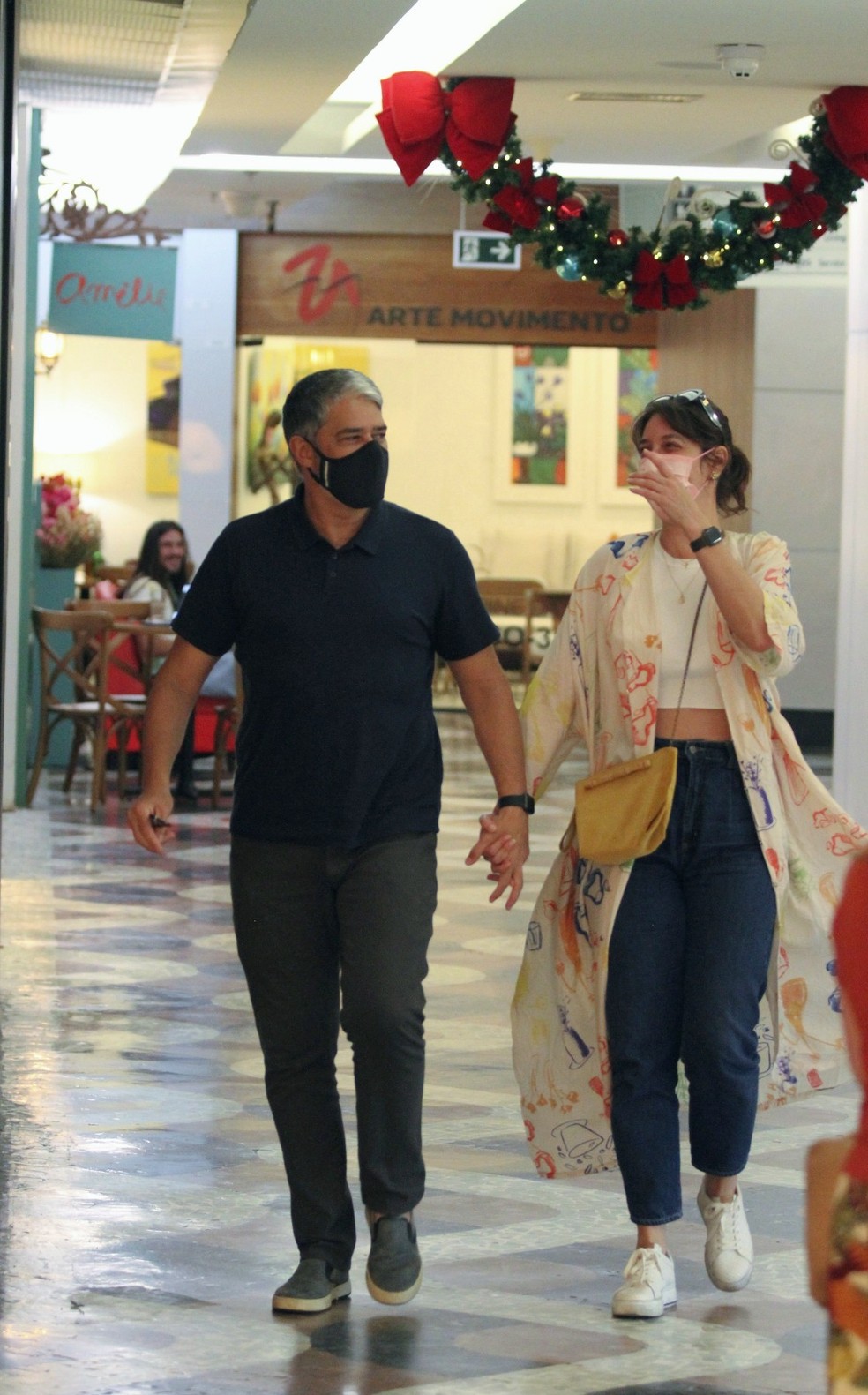 William Bonner passeia de mãos dadas com Natasha Dantas em shopping