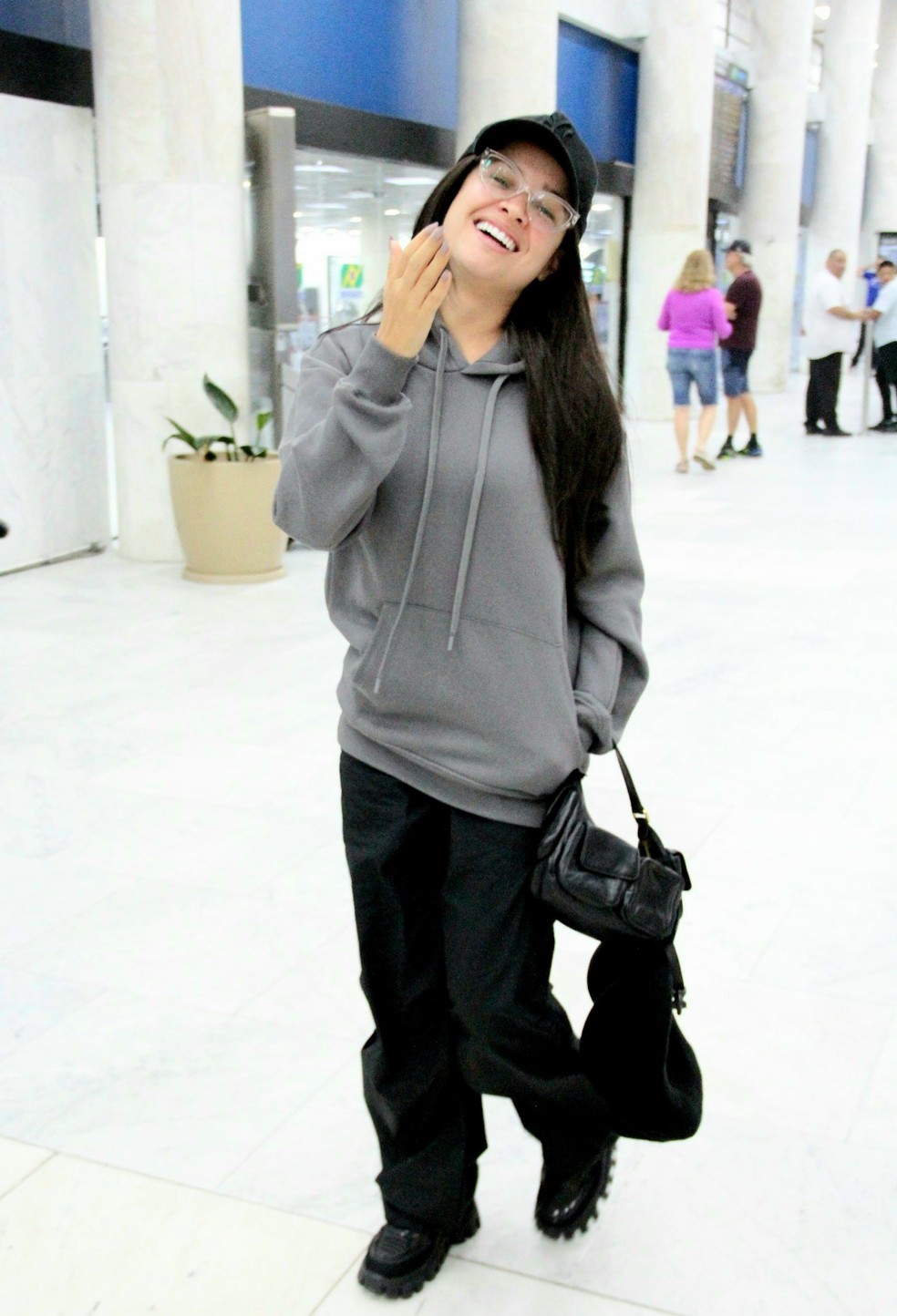 Com sono, Juliette esconde o rosto e boceja ao desembarcar no Rio