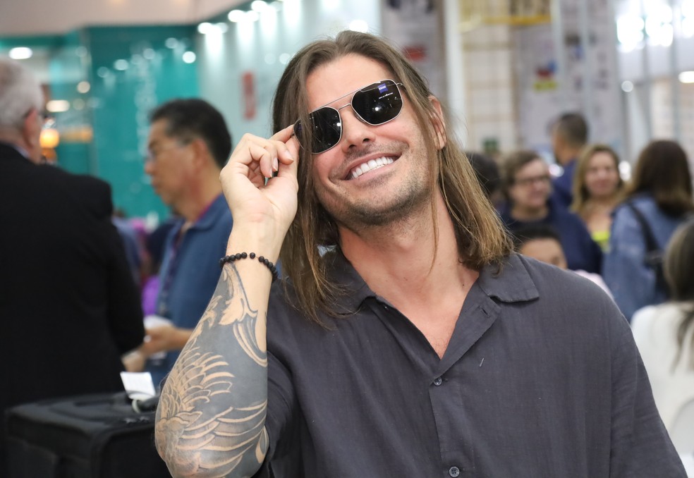 Dado Dolabella vai a evento cercado de seguranças, e posa com fãs