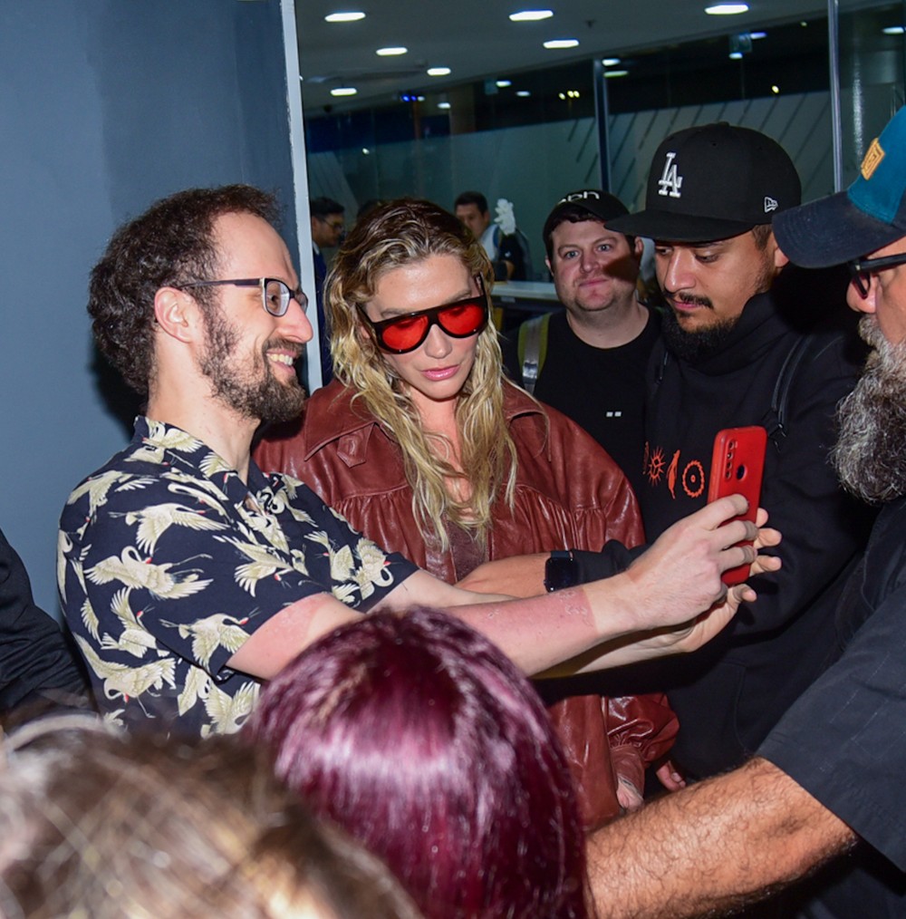 Kesha posa no aeroporto de Guarulhos e atende fãs após show; veja fotos