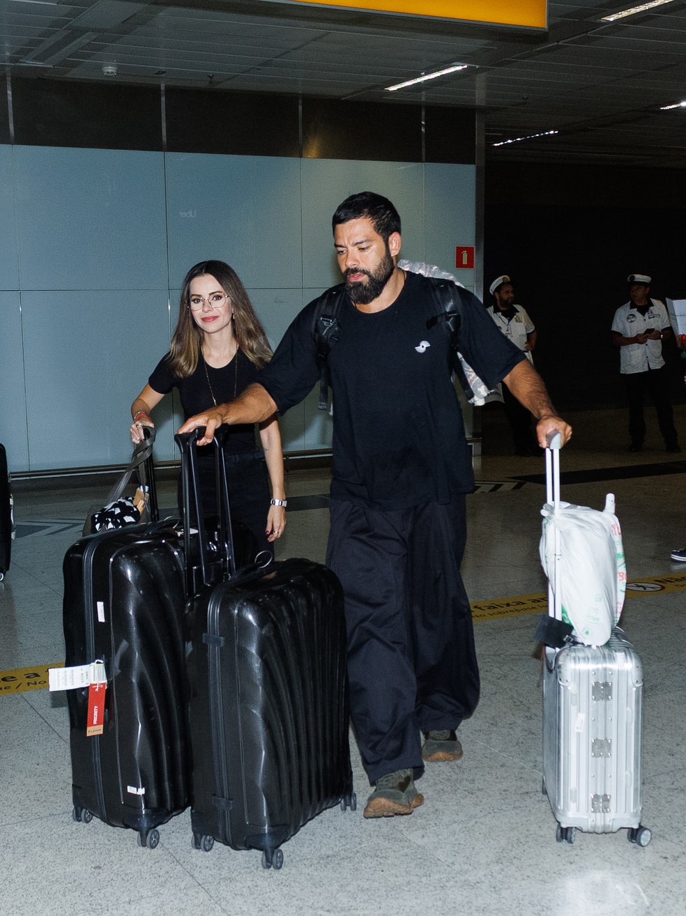 Sandy e namorado, Pedro Andrade, trocam beijos ao desembarcar em São Paulo