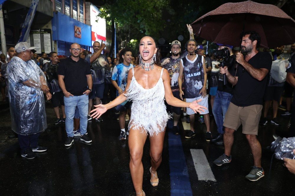 Debaixo de forte chuva, Sabrina Sato samba muito em ensaio de rua da ...