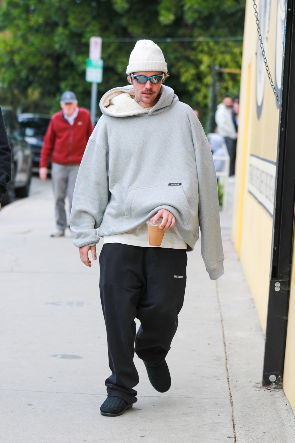 Justin Bieber segura copo de café de maneira inusitada durante caminhada