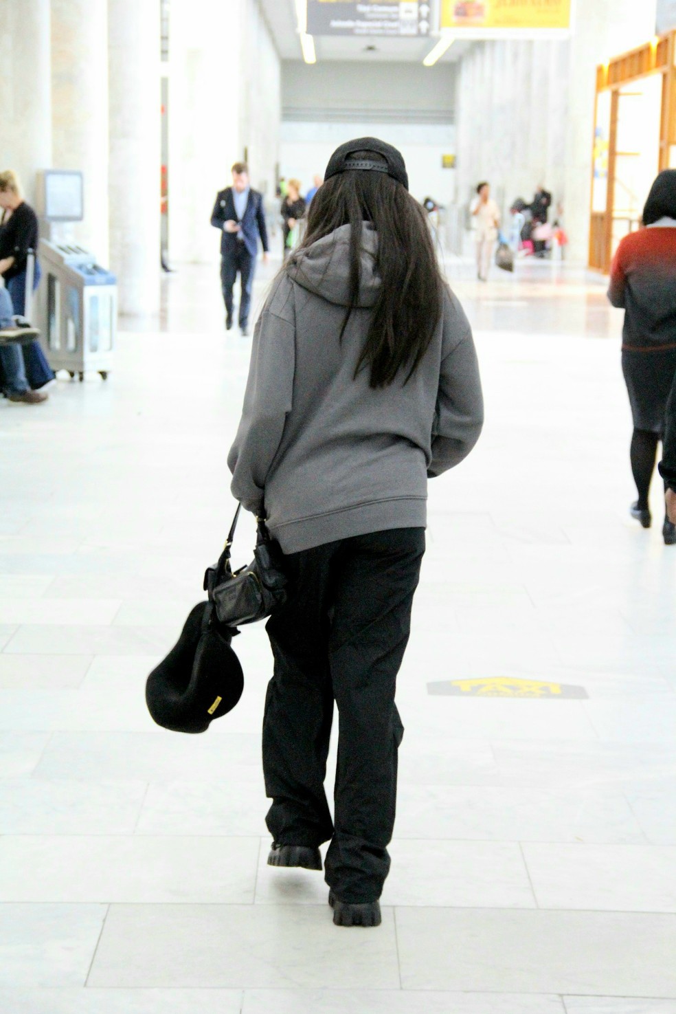 Com sono, Juliette esconde o rosto e boceja ao desembarcar no Rio