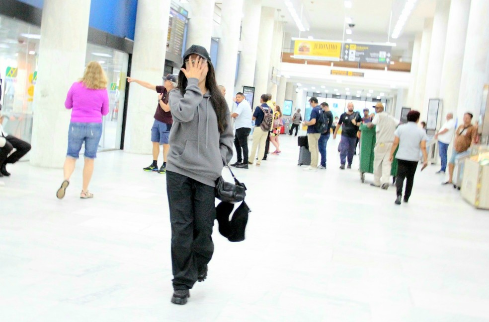 Com sono, Juliette esconde o rosto e boceja ao desembarcar no Rio