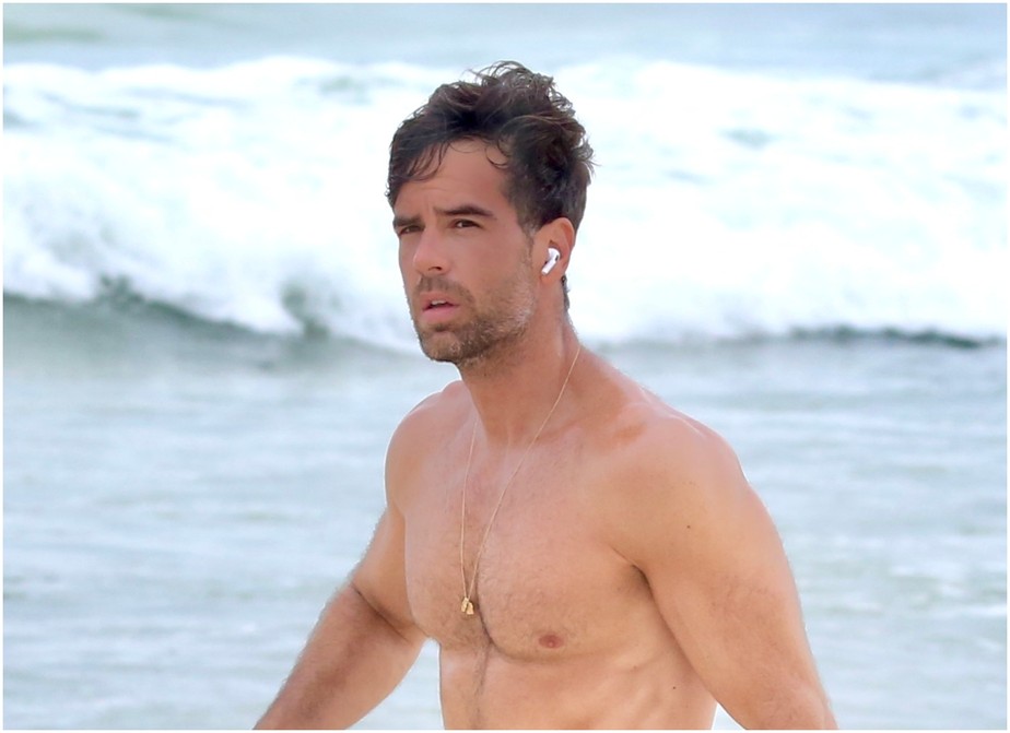 Marcos Pitombo caminha à beira-mar no Rio e exibe abdômen trincado