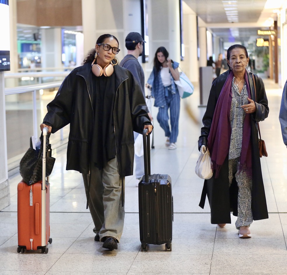 Sorridente, Taís Araujo esbanja estilo ao embarcar com a mãe no Rio; fotos