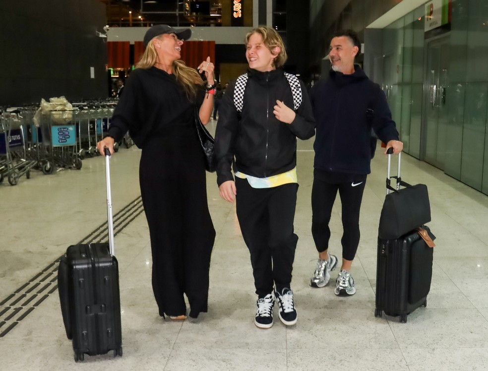 Adriane Galisteu embarca com Alexandre Iódice e Vittorio para o Japão