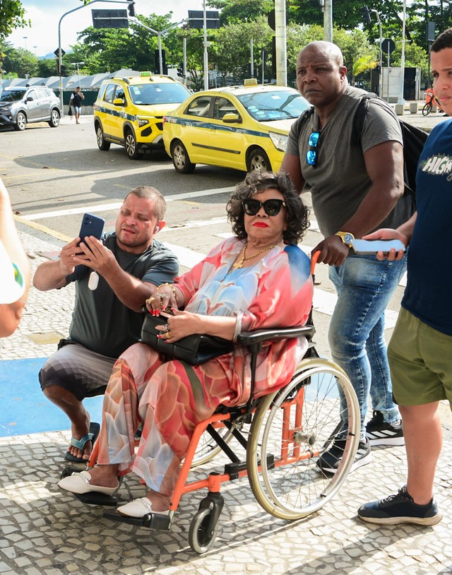 Alcione desembarca de cadeira de rodas em aeroporto do Rio; fotos