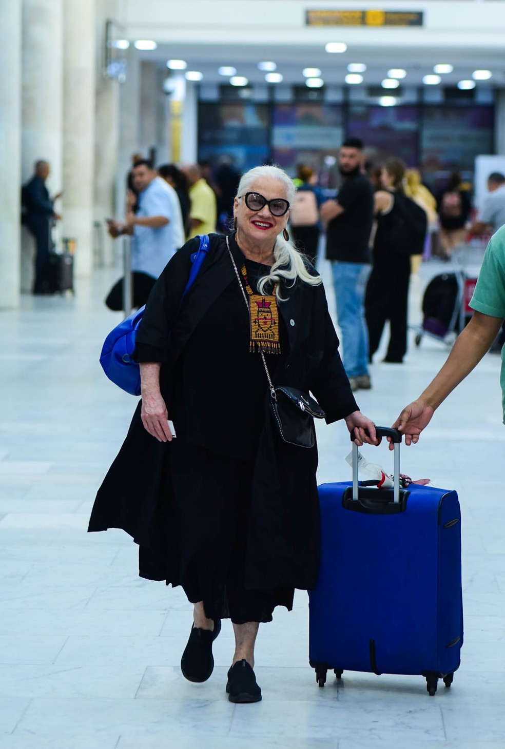 Vera Holtz mostra estilo e simpatia ao desembarcar no Rio de Janeiro; fotos