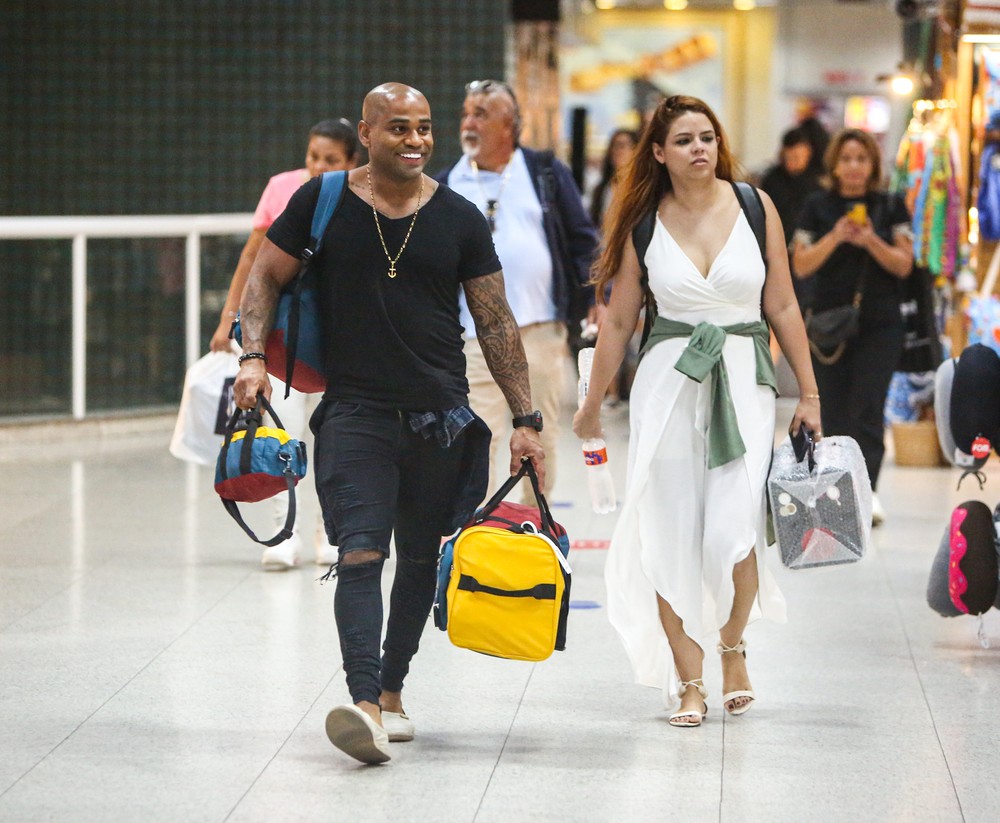 Sorridente, ex-BBB Cezar Black posa com fãs em aeroporto do Rio