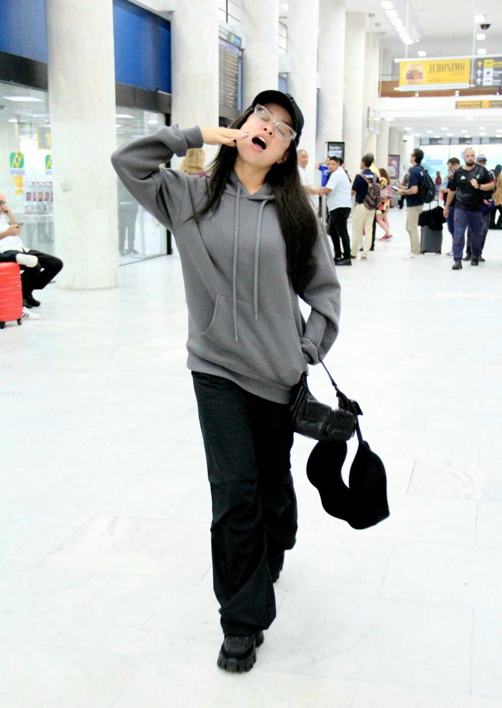 Com sono, Juliette esconde o rosto e boceja ao desembarcar no Rio