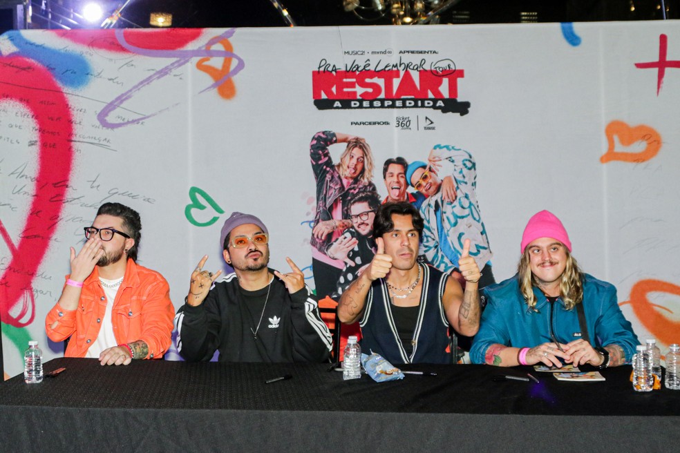 Integrantes da banda Restart atendem fãs em ação de turnê de despedida