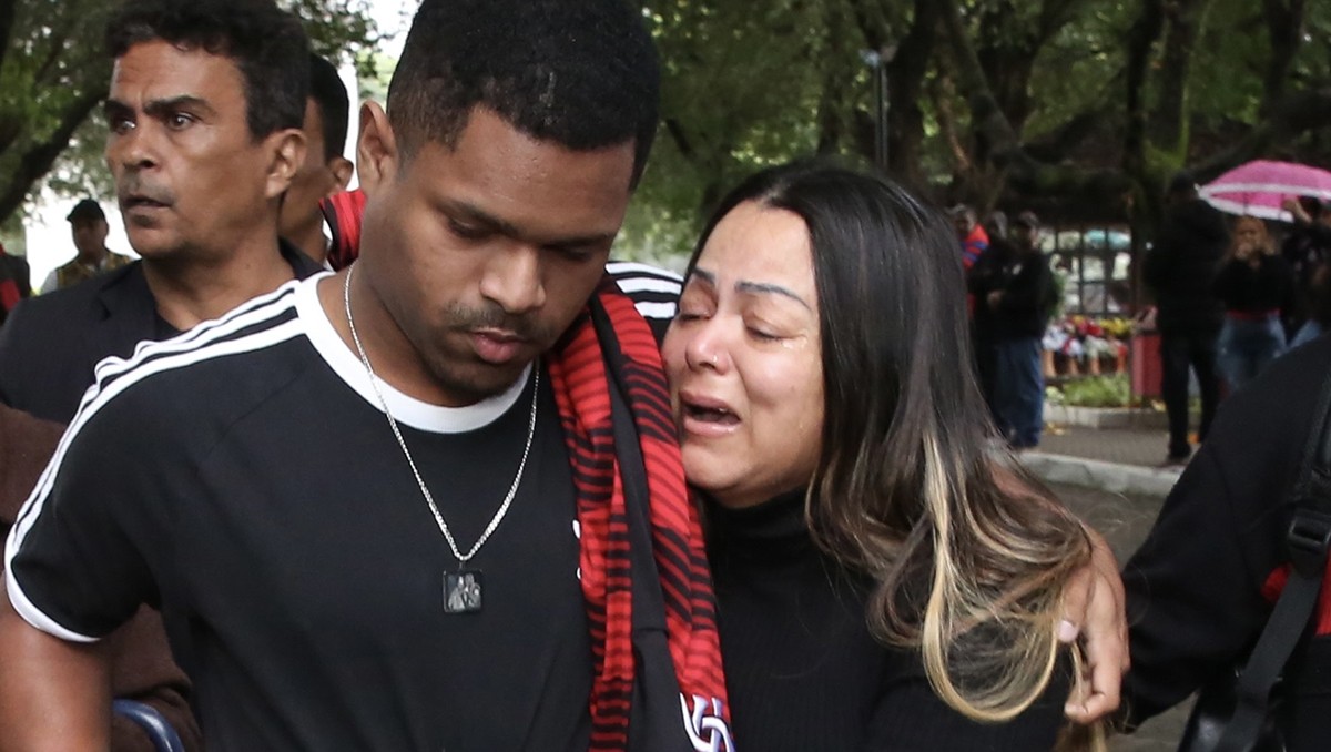 Mc Cacau, ex-mulher de Mc Marcinho, chega aos prantos e amparada em velório