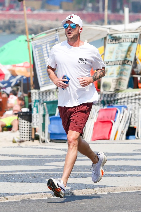 Ryan Tedder, do OneRepublic, corre com o celular na mão em orla antes ...