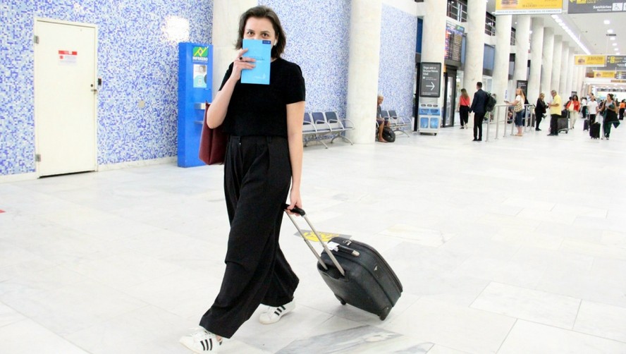 De visual novo, Monica Iozzi esconde rosto em chegada a aeroporto no Rio