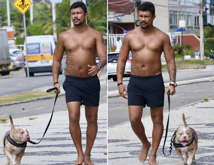 Sem camisa e descalço, Xamã passeia com seu cachorro pela orla do Rio