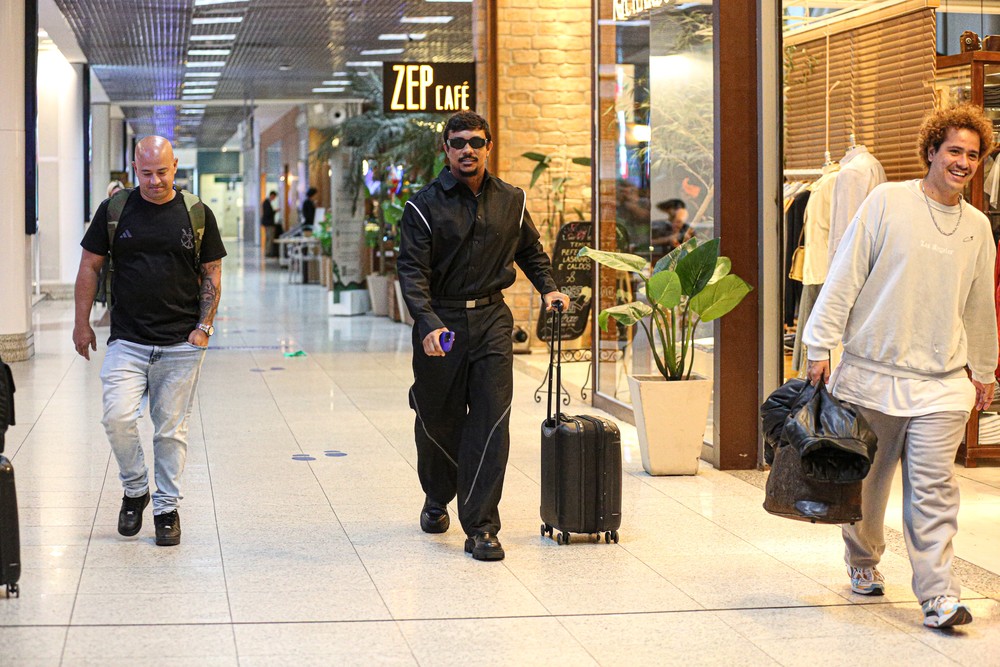De óculos escuros e conjunto preto, Xamã embarca no Rio de Janeiro