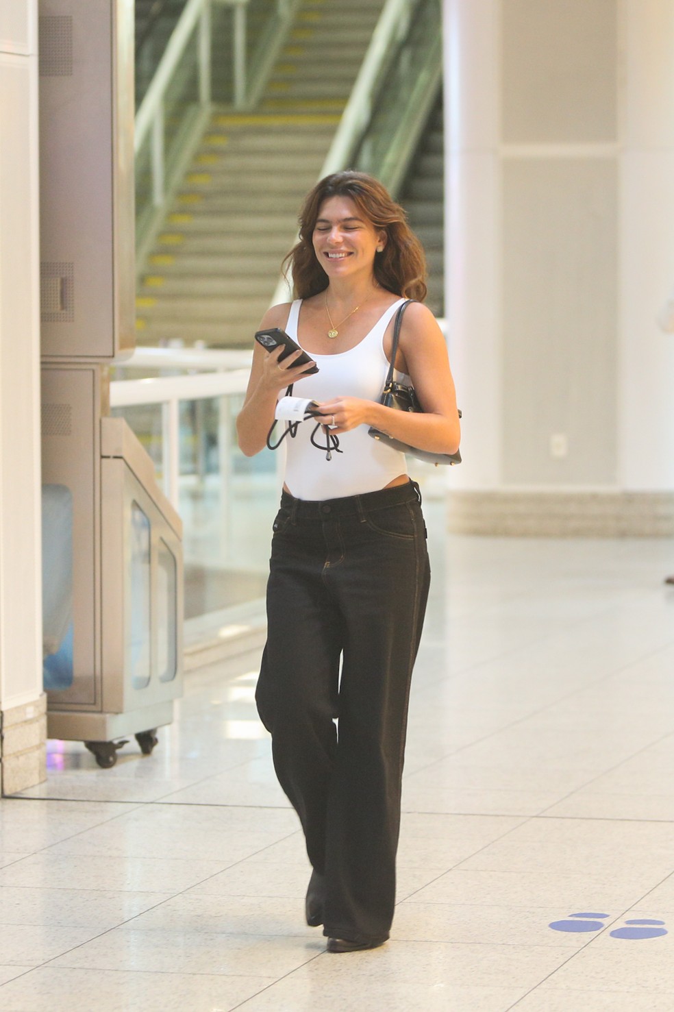 De body e calça oversized, Mariana Goldfarb abre sorrisão ao embarcar ...