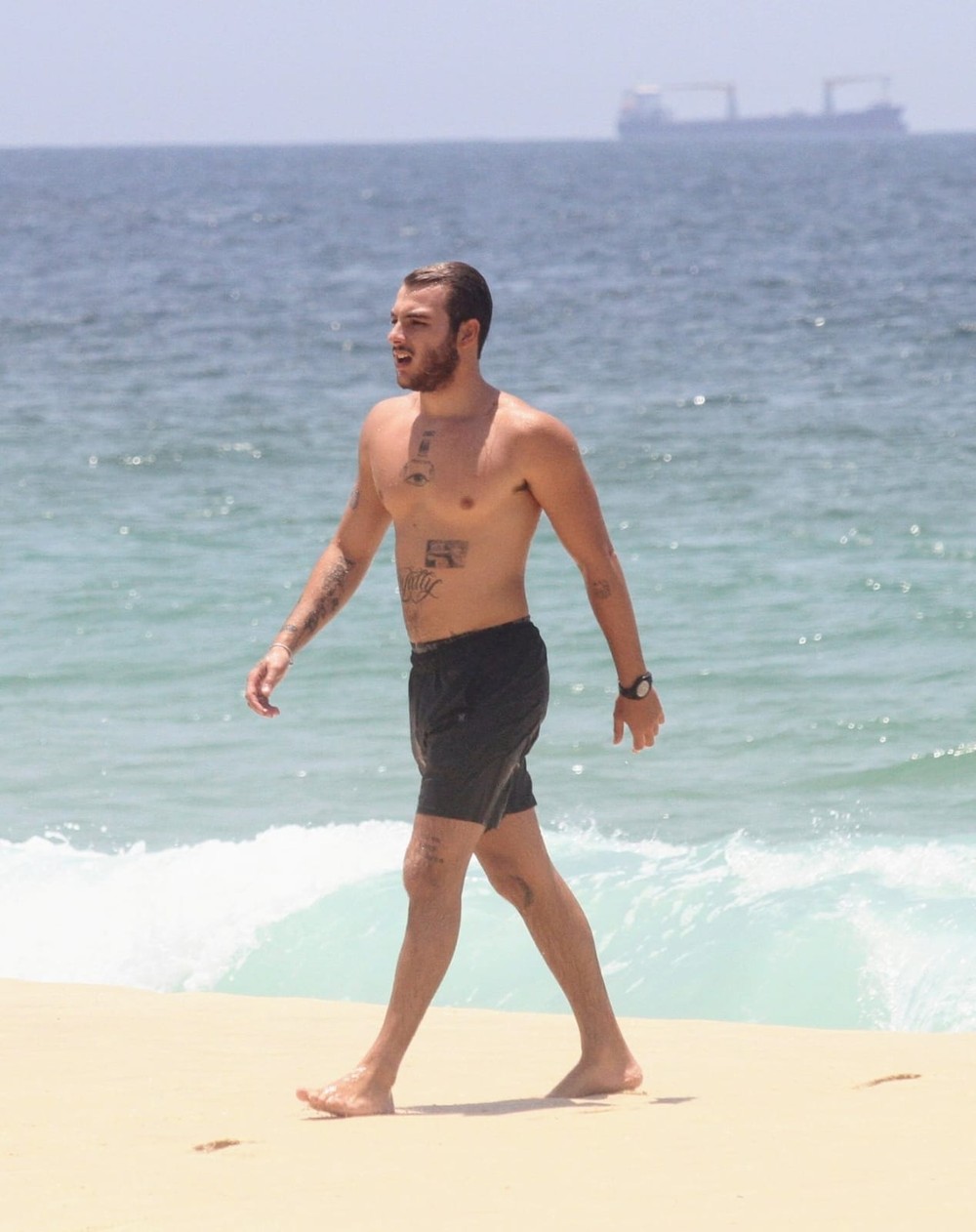 Filho de Patrícia Poeta surfa em praia carioca e exibe corpo tatuado