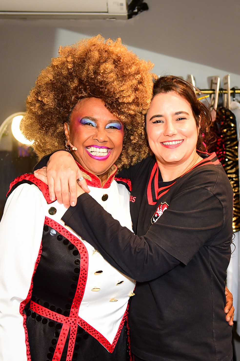 Vestida de Xuxa, Sandra Sá troca beijos com a mulher, Simone Malafaia