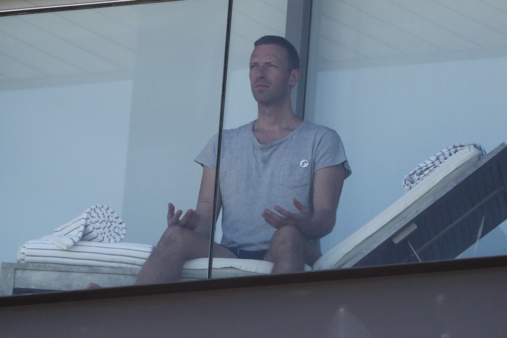 Chris Martin, do Coldplay, relaxa em varanda enquanto Dakota Johnson ...