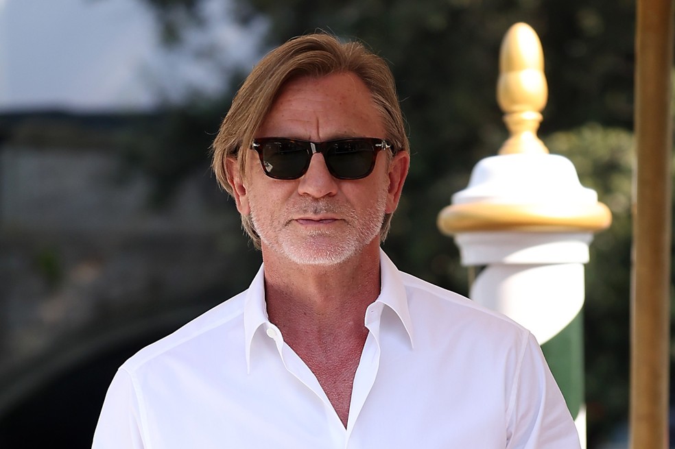 Daniel Craig estreia novo visual no Festival de Veneza; compare