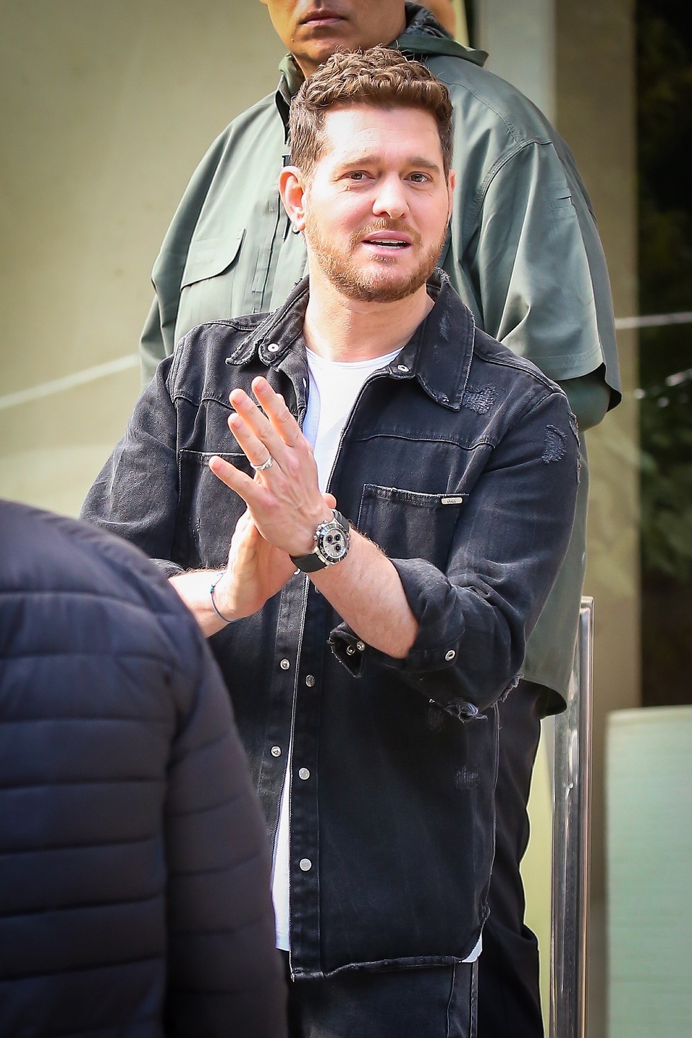 Michael Bublé acena para fãs e exibe tatuagem ao deixar hotel em São Paulo